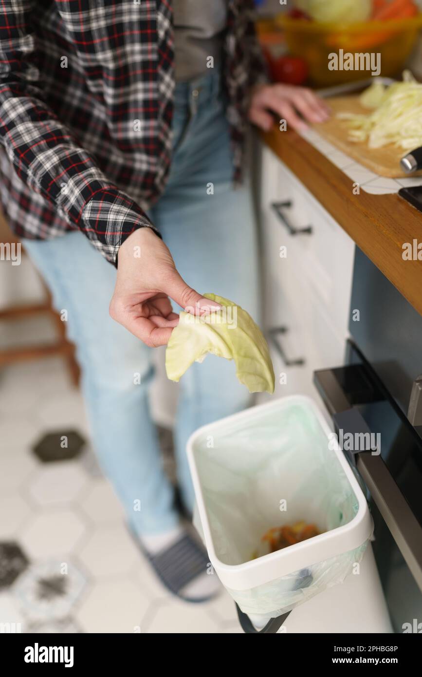 Female composting organic wood waste at home. Woman throwing cabbage ...