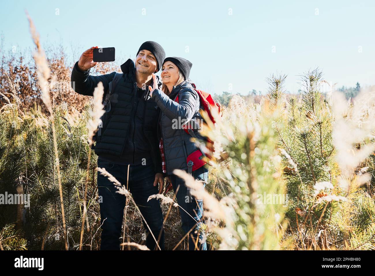 Couple having video call sending greetings from vacation trip. Hikers ...
