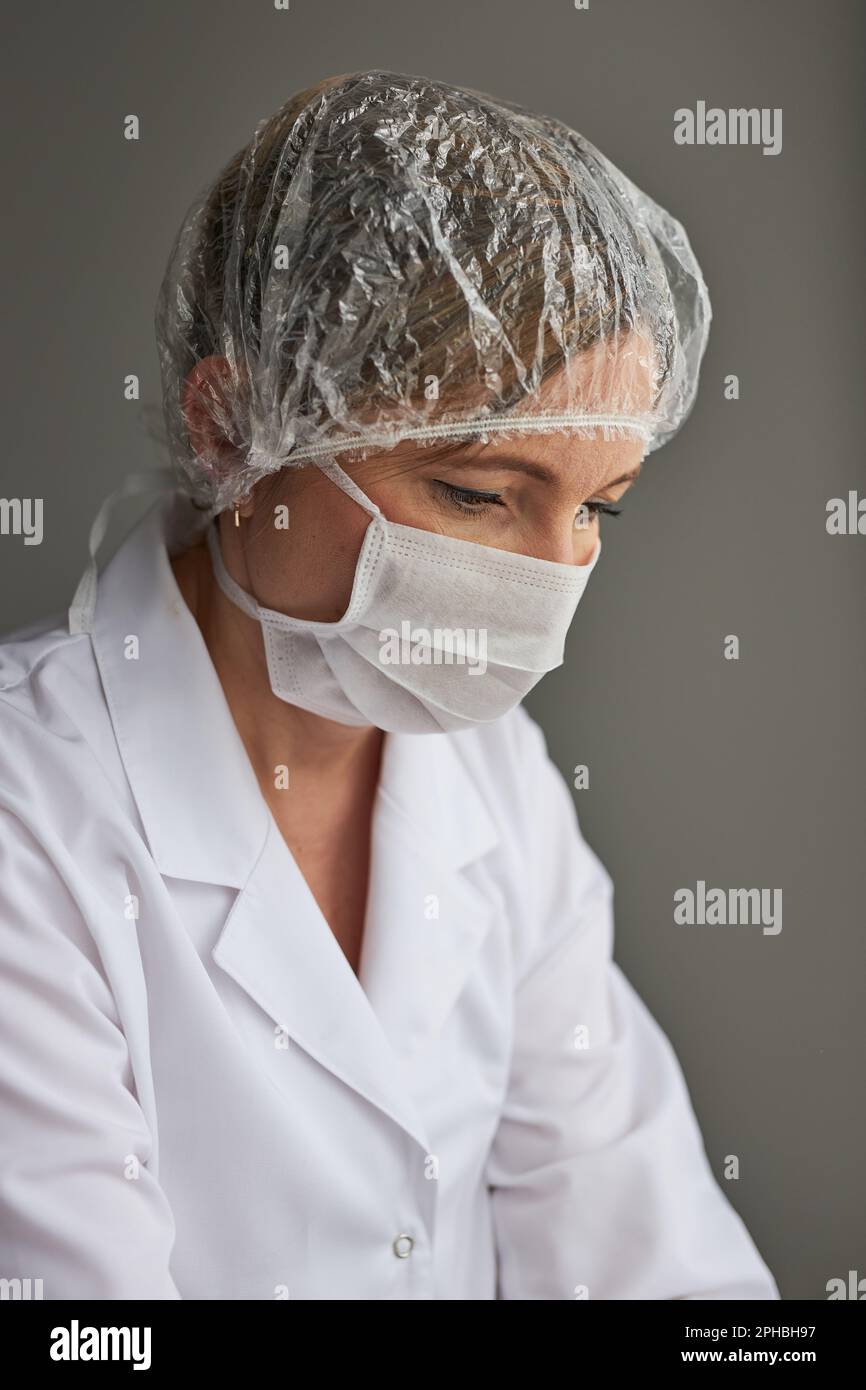 Doctor with face covered with mask. Portrait of young woman wearing the ...