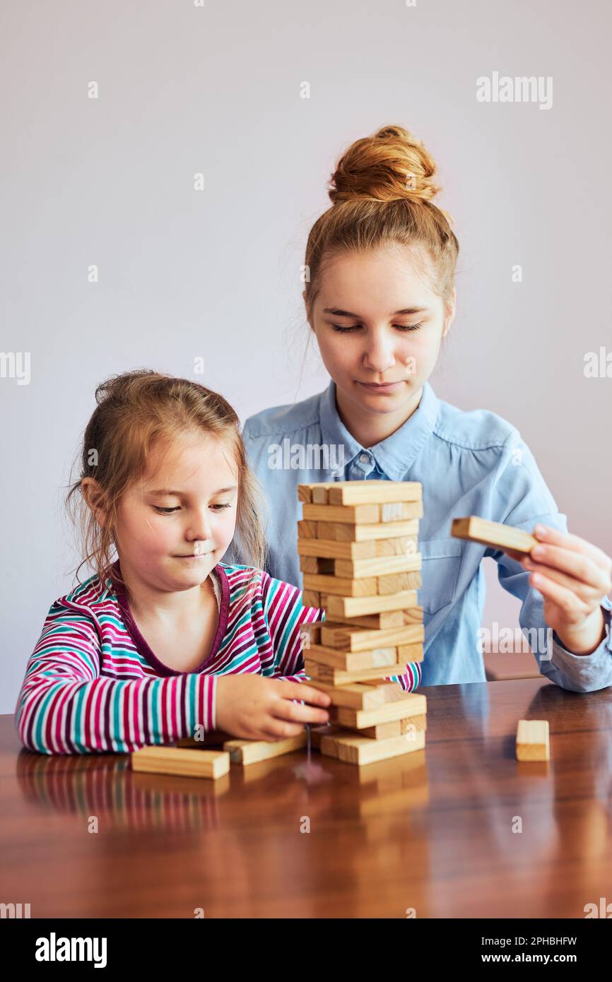 Little girl preschooler and her elder sister playing together with ...
