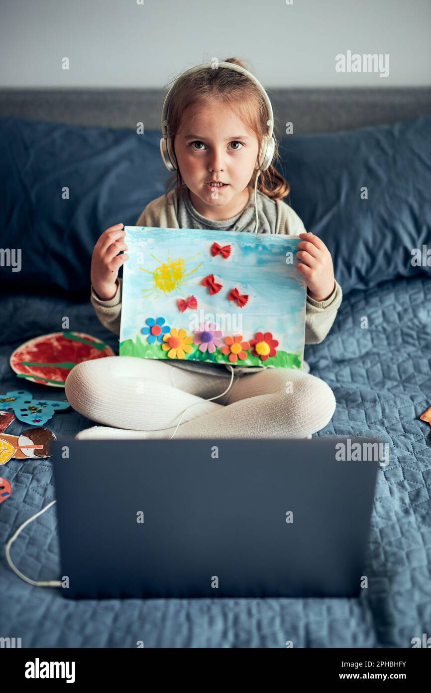 Little girl preschooler learning online showing her works drawings done ...