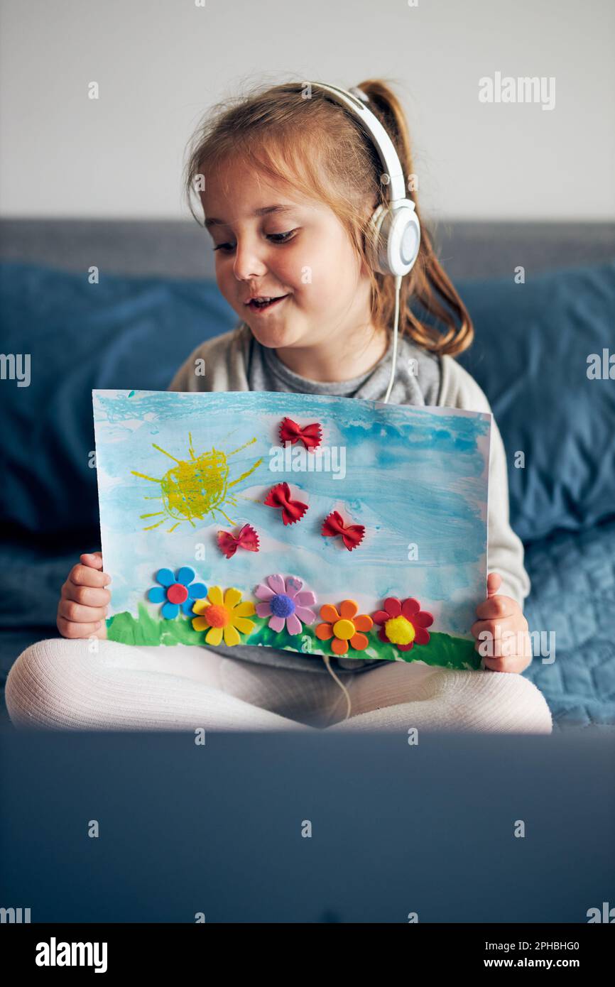 Little girl preschooler learning online showing her works drawings done ...