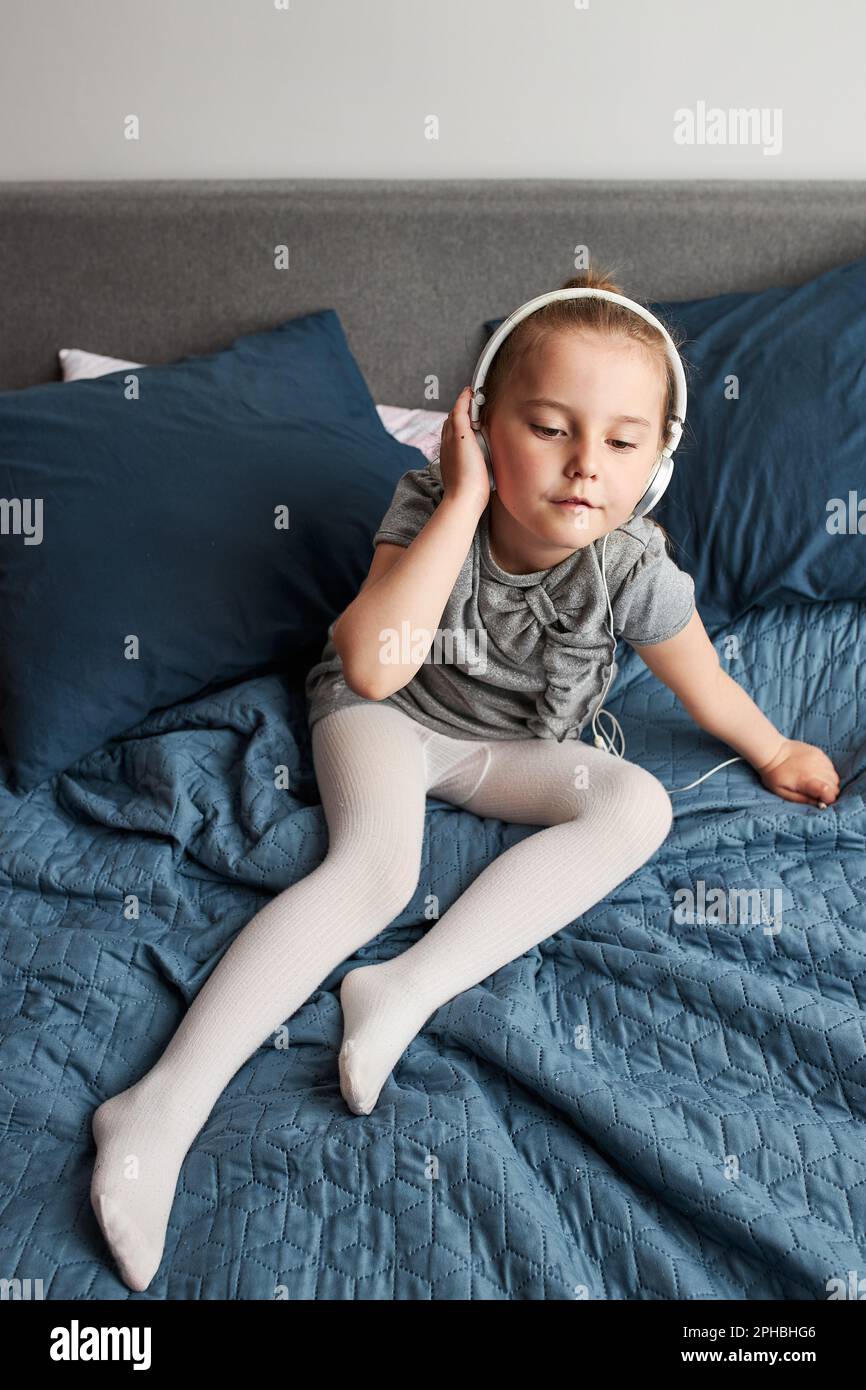 Little girl singing holding headphones cord imitating herself a real ...