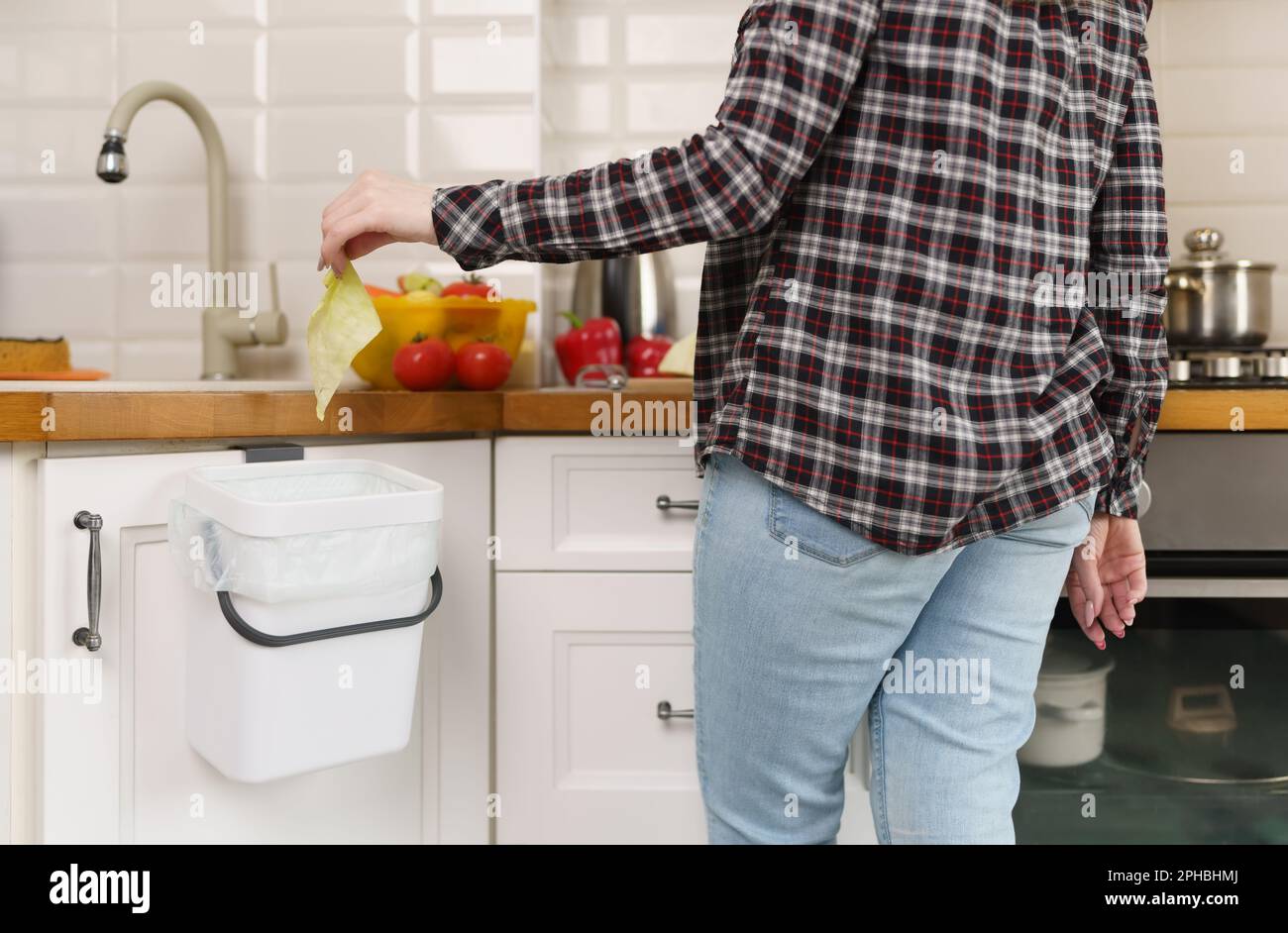 Woman throwing food waste in a composter bin. Female person cooking at ...