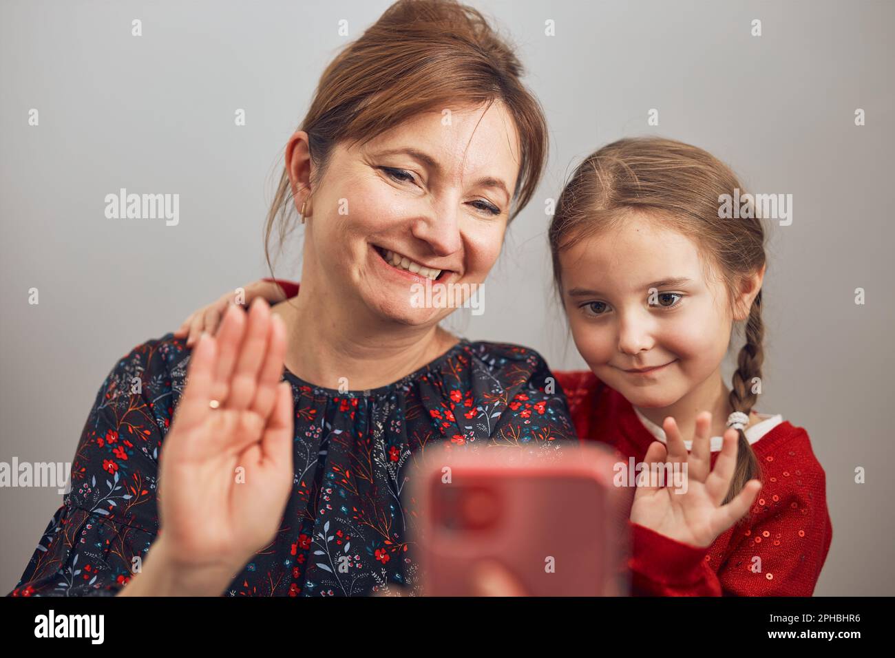 Mother with her little daughter making video call using mobile phone ...