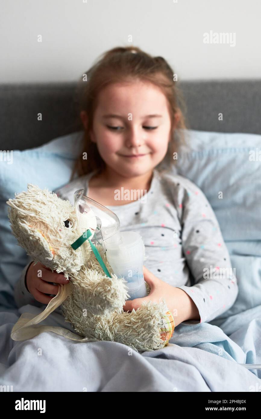 Sick child recovering in bed. Little girl playing by applying medical ...