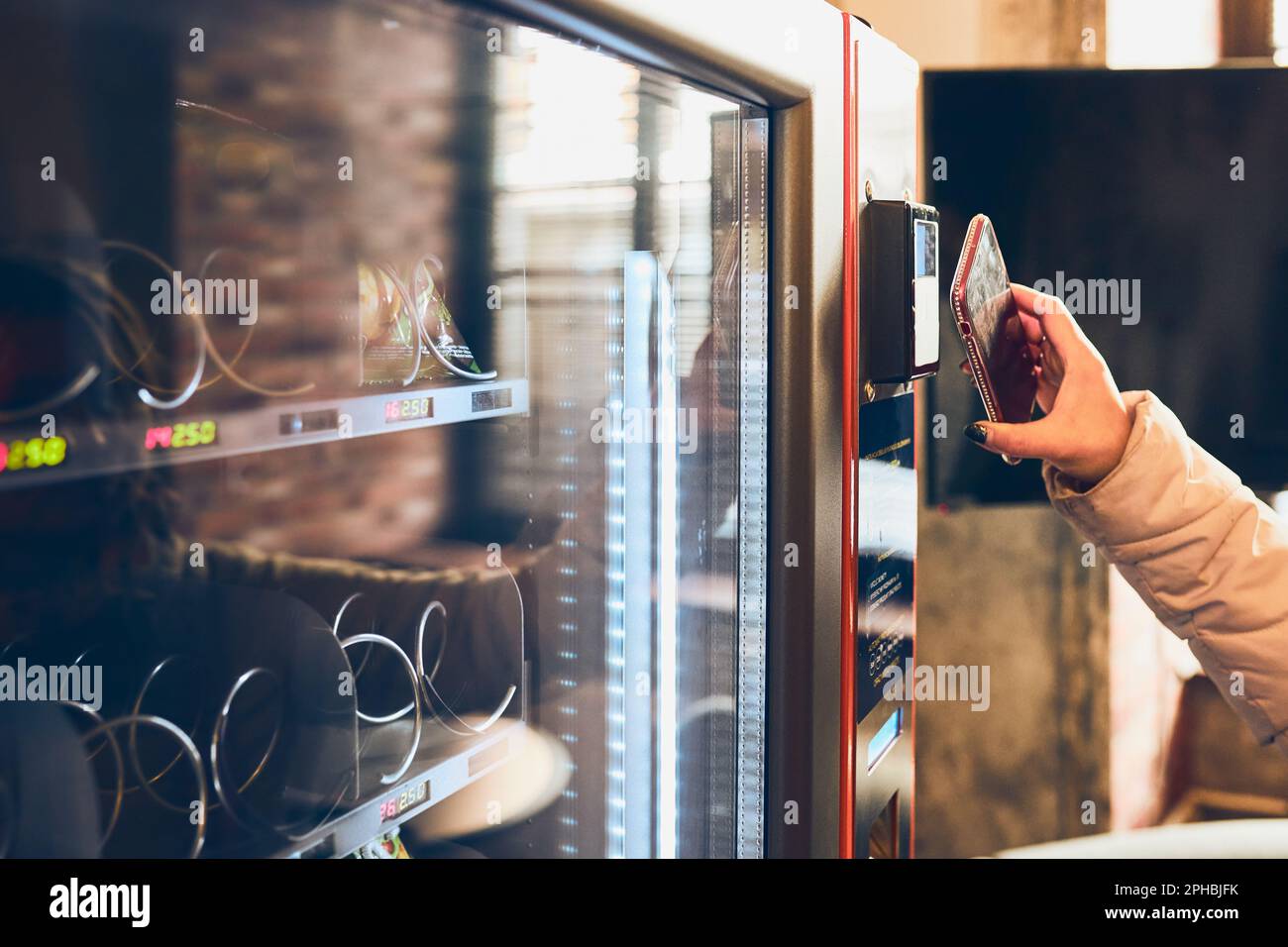Woman paying for product at vending machine using contactless method of ...