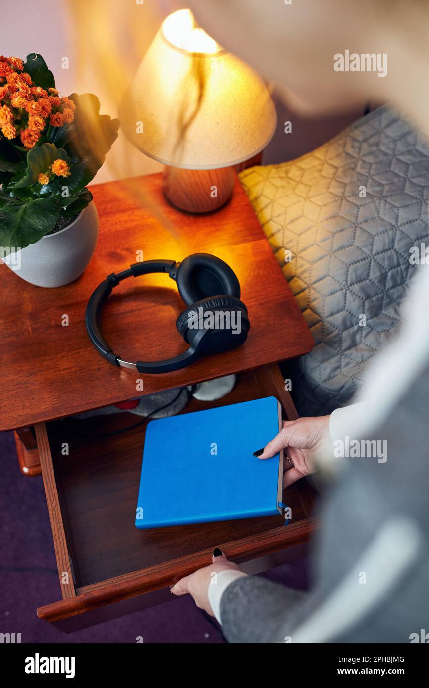 Young woman pulling diary from bedside drawer. Writing journal. Making ...