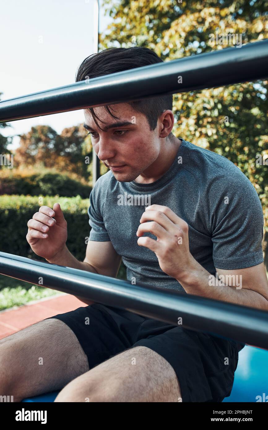 Young man doing sit-ups during his workout in a modern calisthenics ...