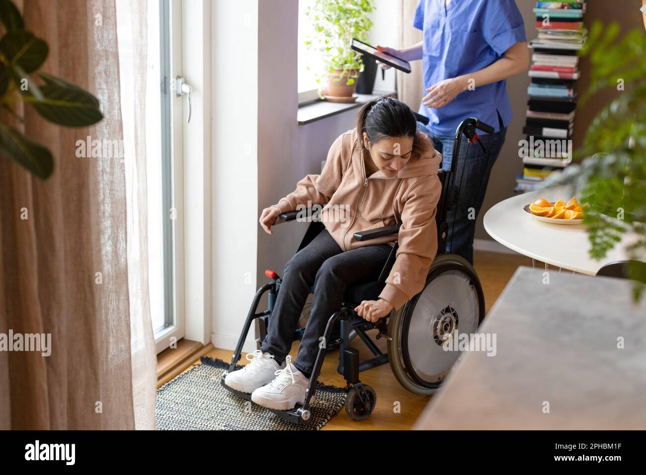 Woman with paraplegia adjusting wheelchair at home Stock Photo - Alamy