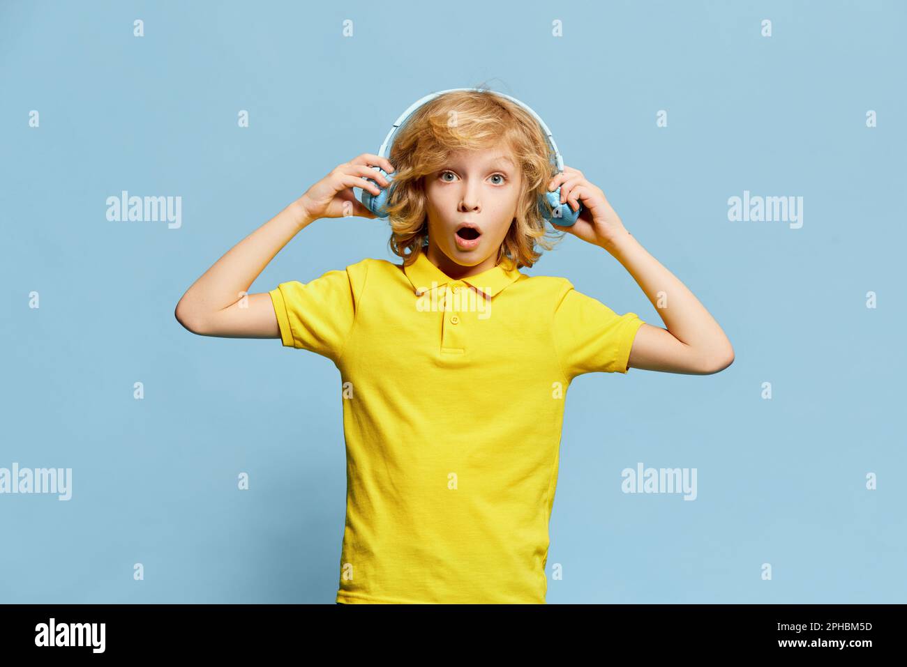 Little boy, child with shocked emotive face posing in headphones ...