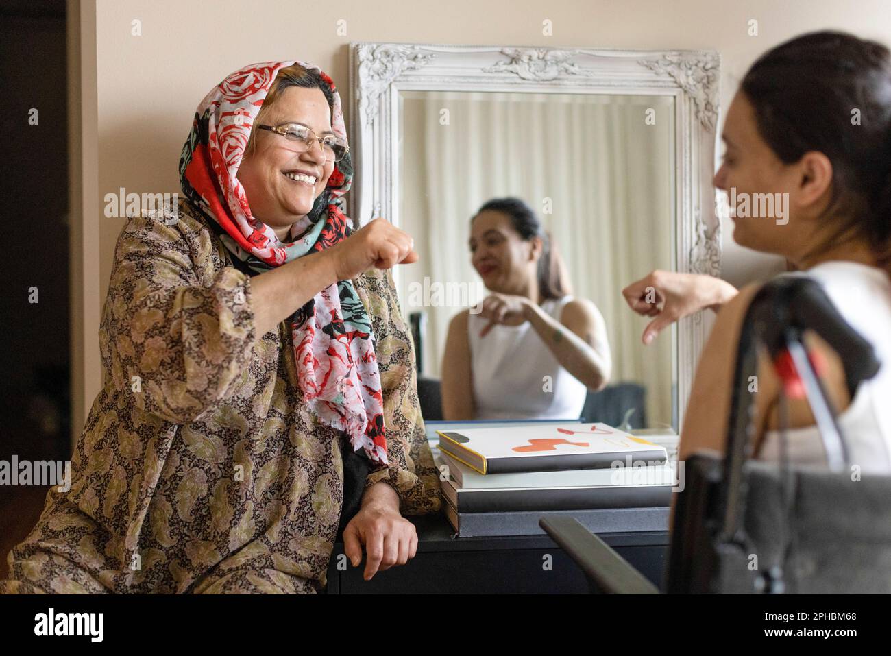 Happy mother giving fist bump to daughter with disability at home Stock ...