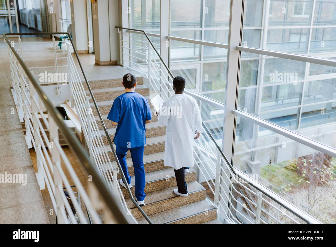 High angle view of male doctor and nurse discussing while moving up on ...
