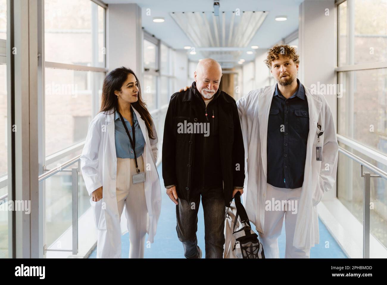 Doctor walking with patient in hospital corridor hi-res stock ...