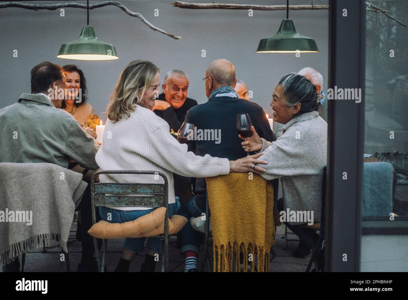 Happy retired women enjoying together with friends at dinner party ...