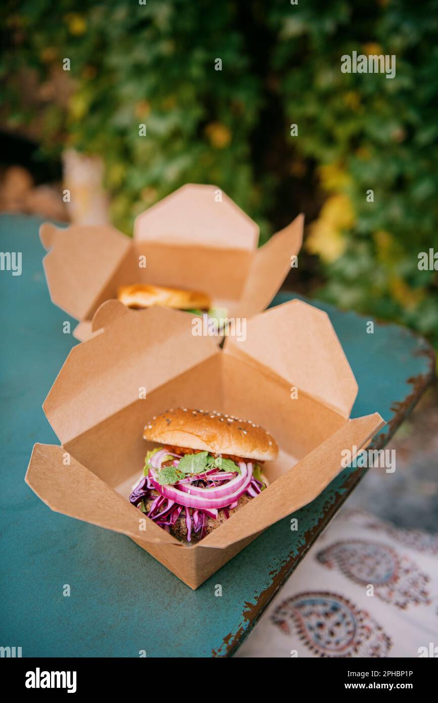 Freshly prepared burgers in take away boxes on table at restaurant ...