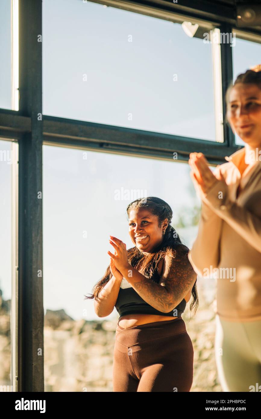 Happy women clapping during yoga class at retreat center Stock Photo ...