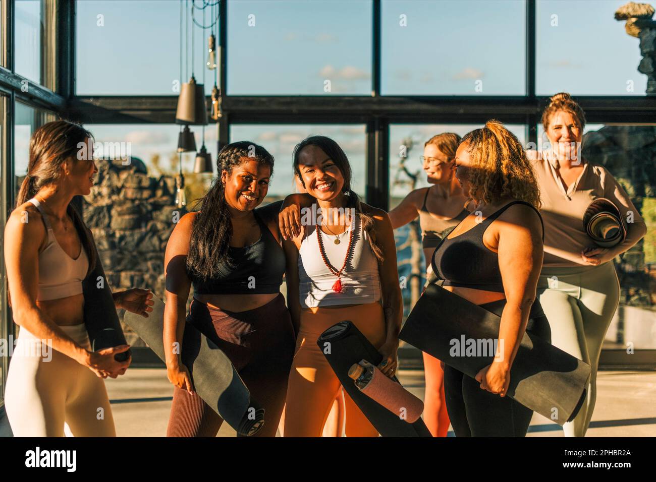 Smiling friends holding yoga mats hi-res stock photography and images ...