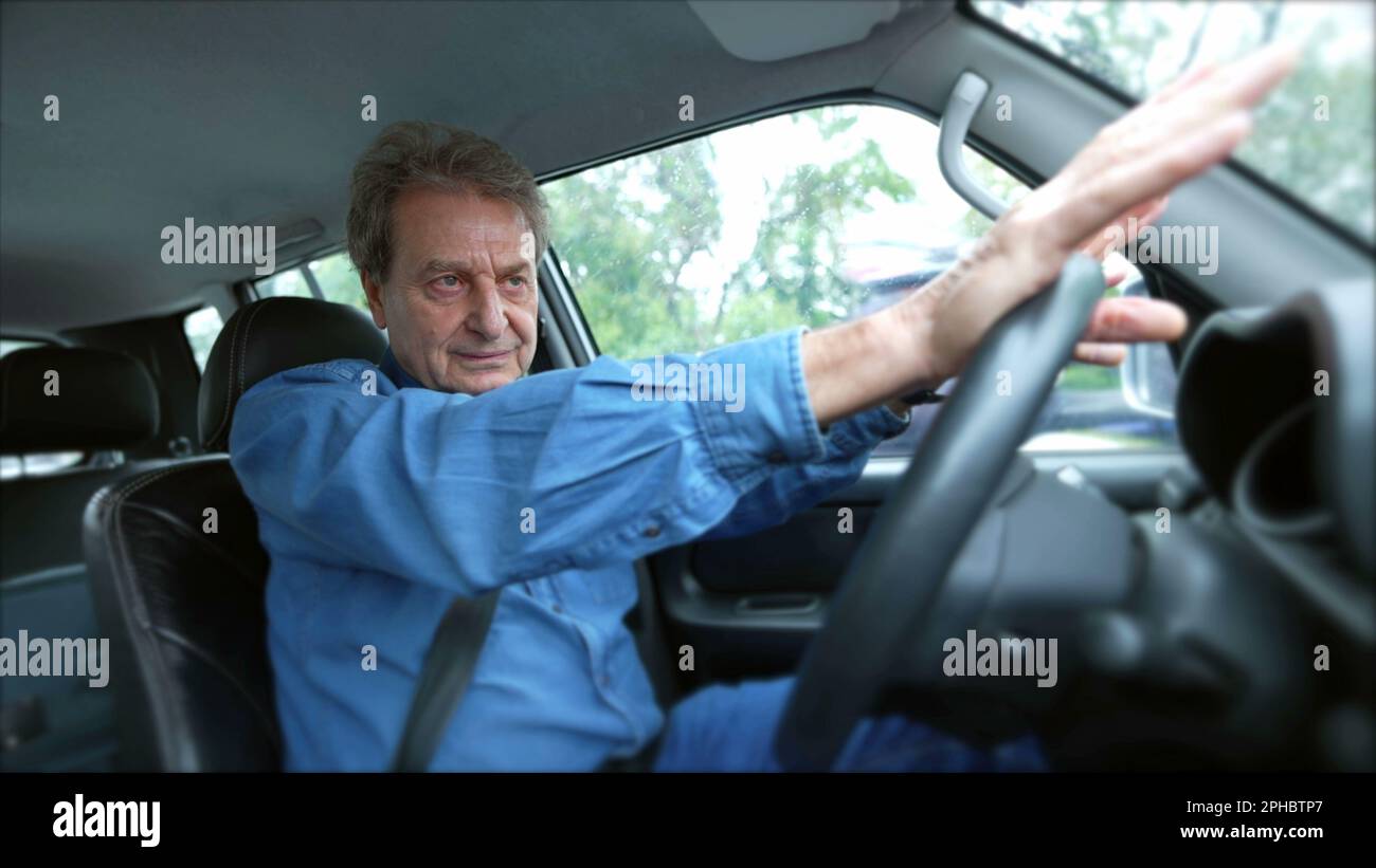 One senior man holding can steering wheel driving in city while talking ...