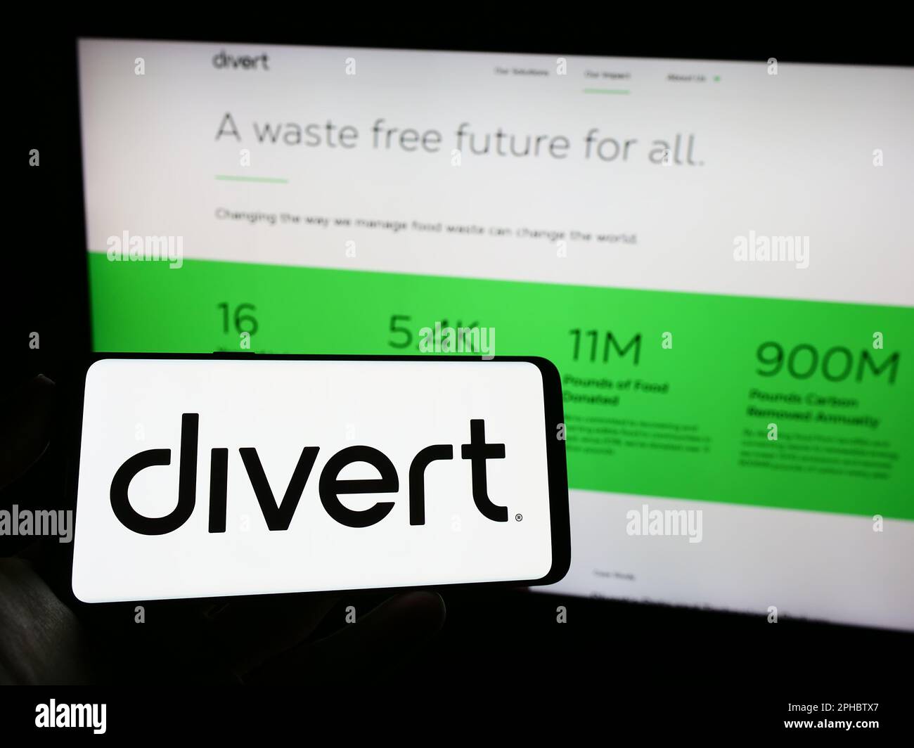 Person holding cellphone with logo of US food technology company Divert ...