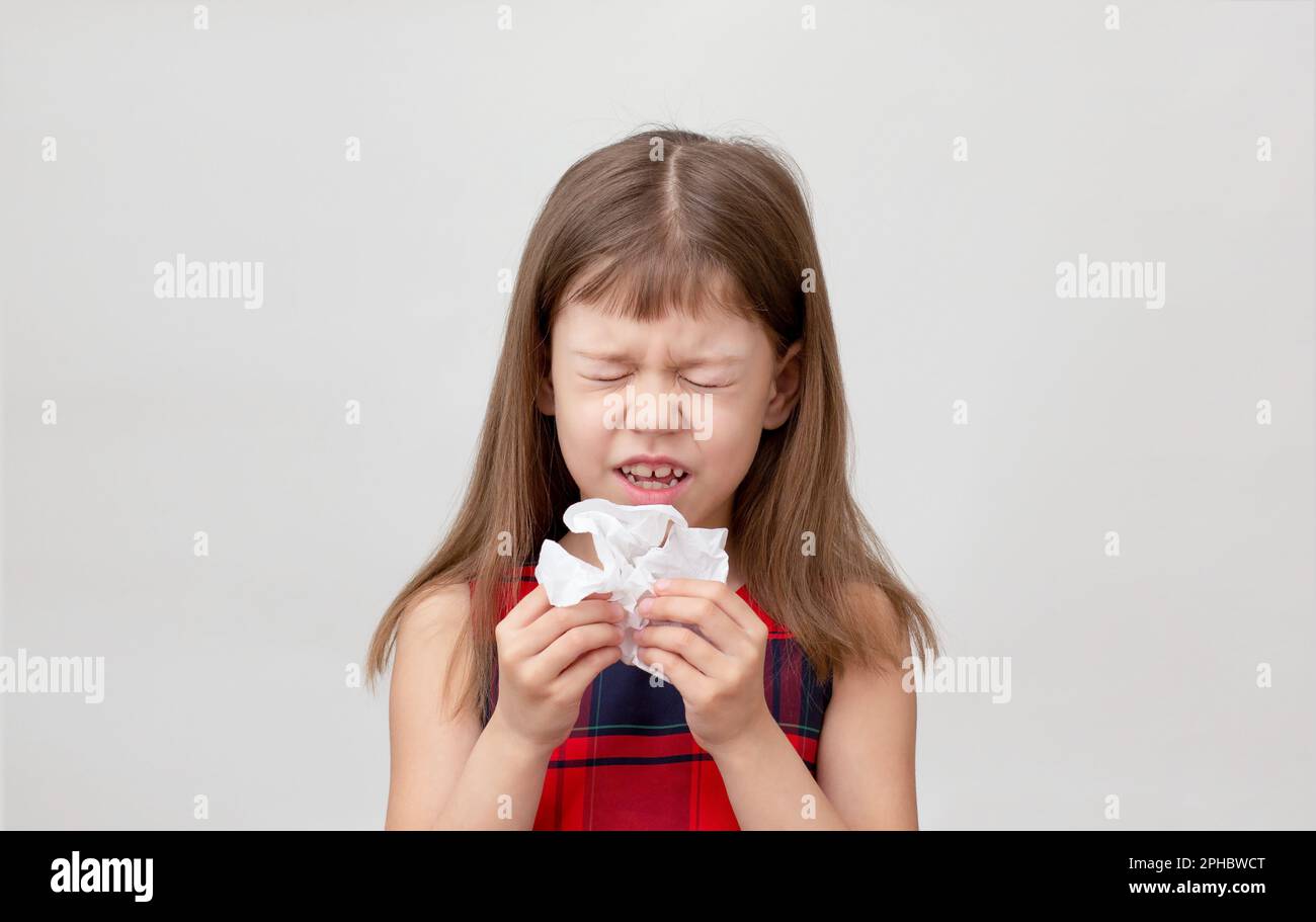 Child going to sneeze into napkin in hands showing allergic rhinitis or ...
