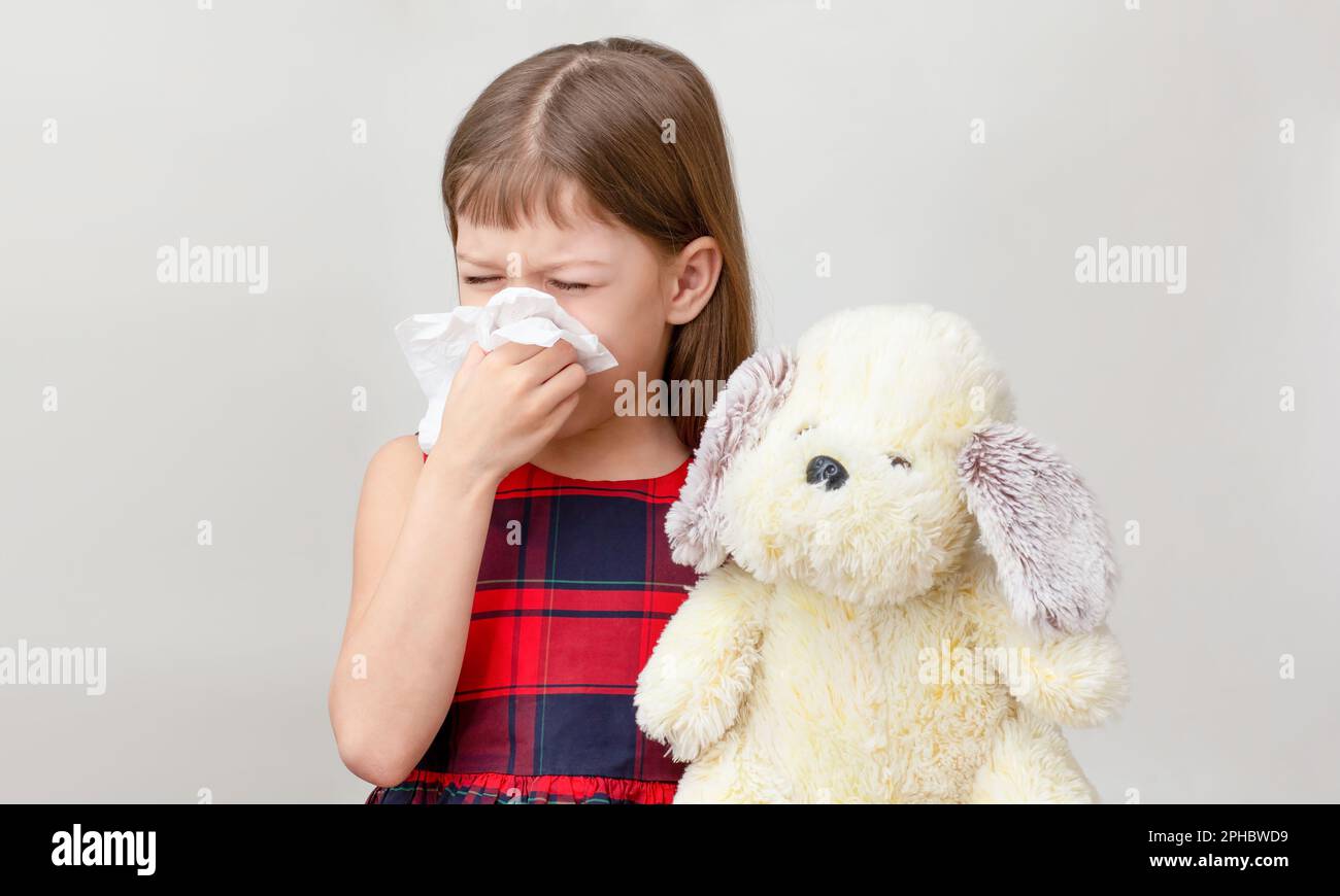 Child holding napkin on nose showing allergy to toys caucasian little ...