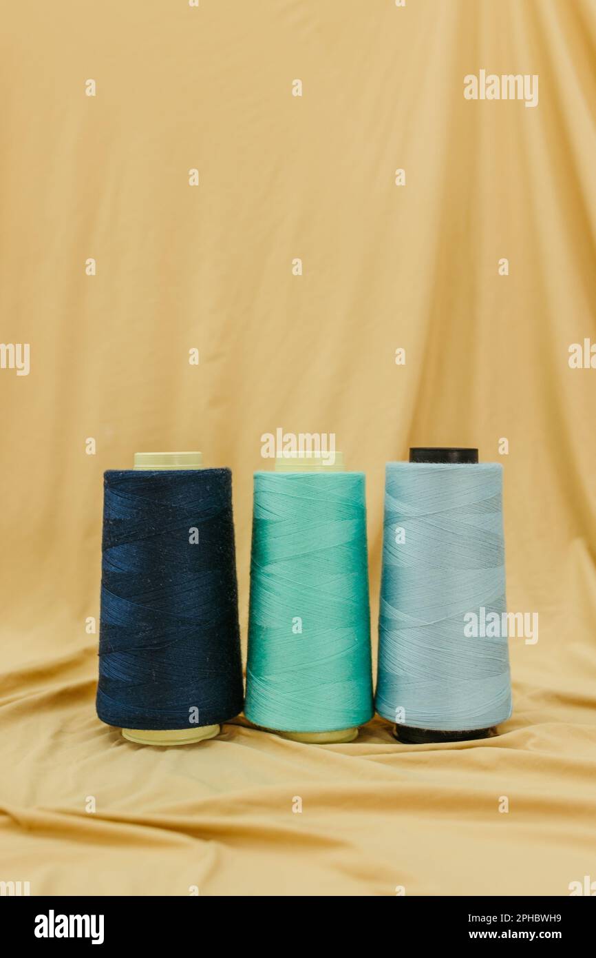 A high-resolution vertical image of three spools of brightly colored ...