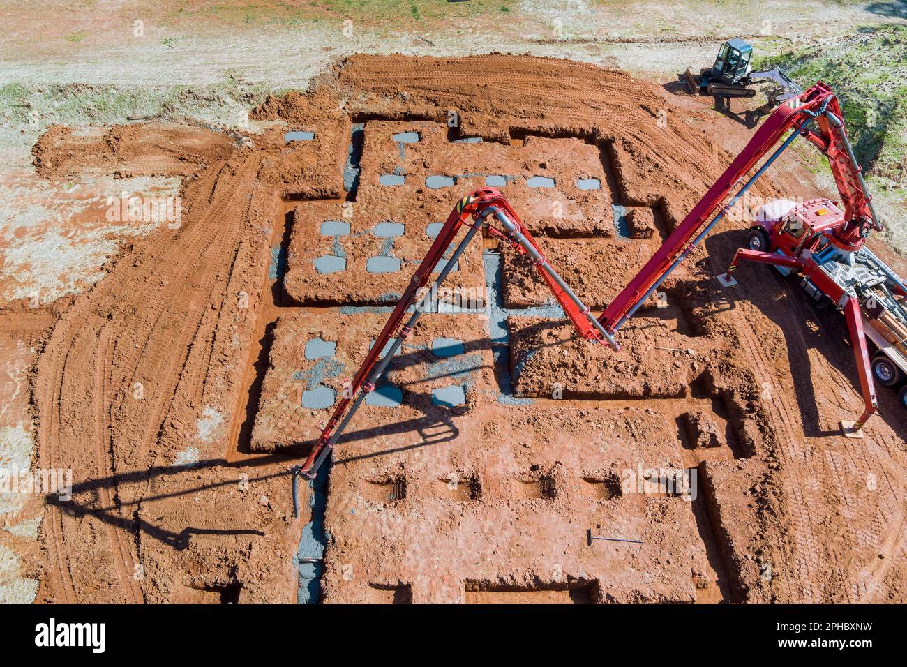 Concrete is being pumped into foundation of house by construction ...