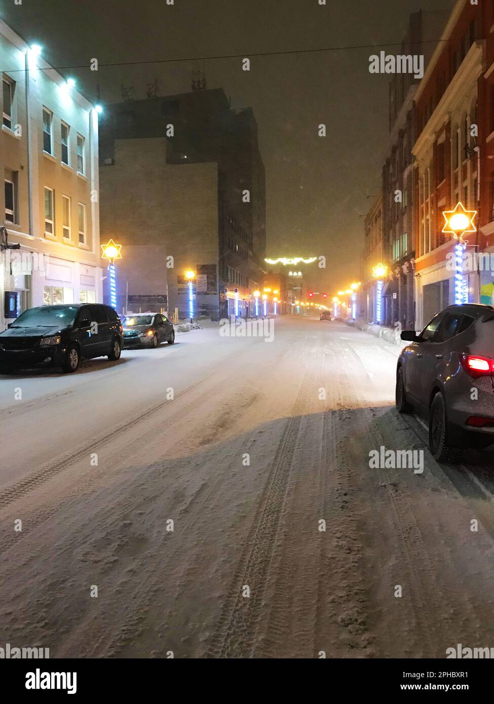 Snow falling on a snow covered city street at night Stock Photo - Alamy