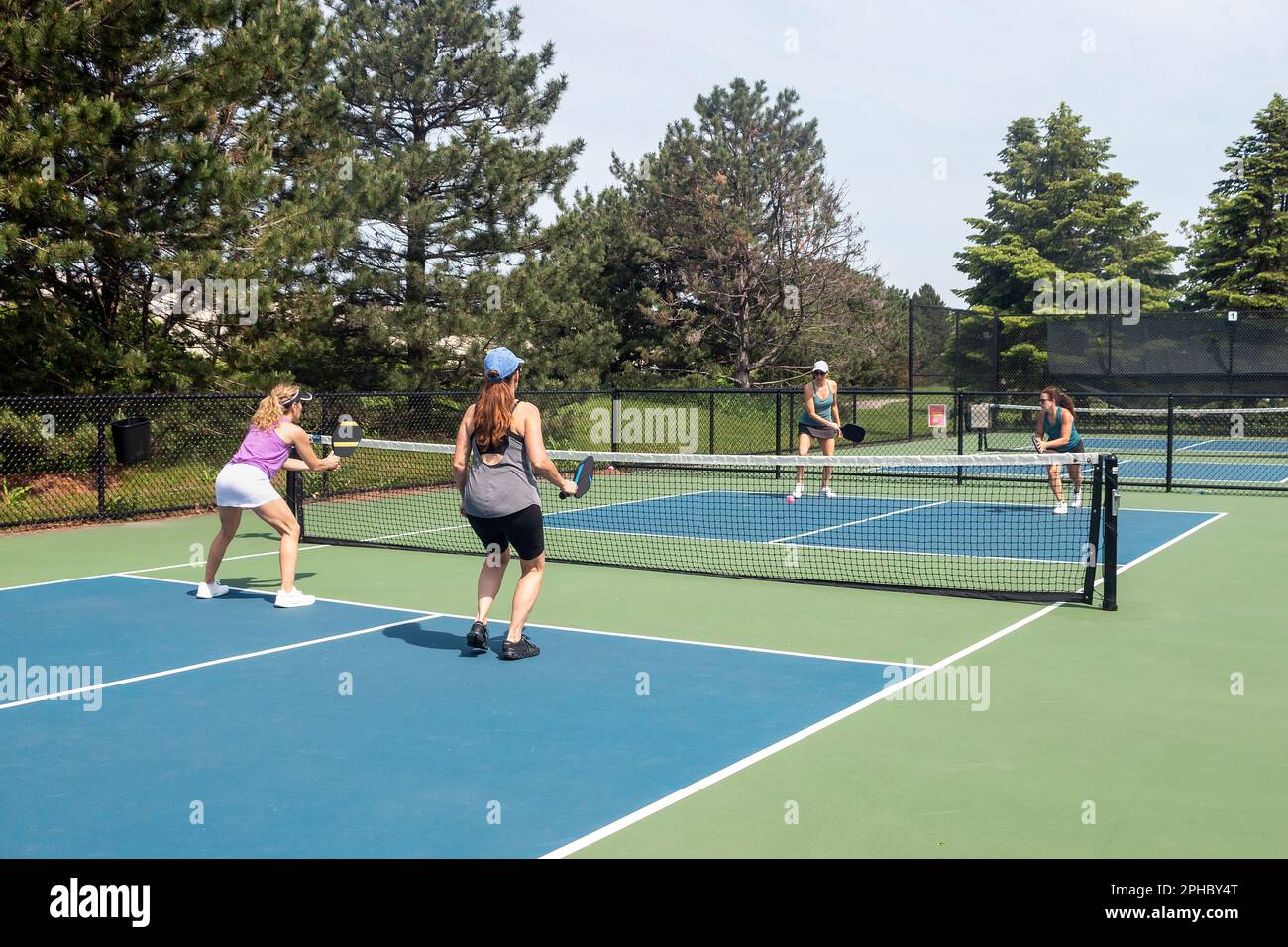 Two players approach the net in a competitive doubles game of ...