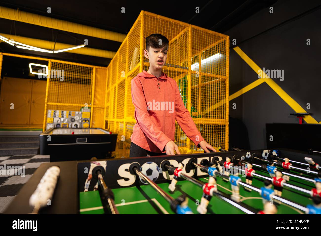 Boy playing table football in kids play center Stock Photo - Alamy
