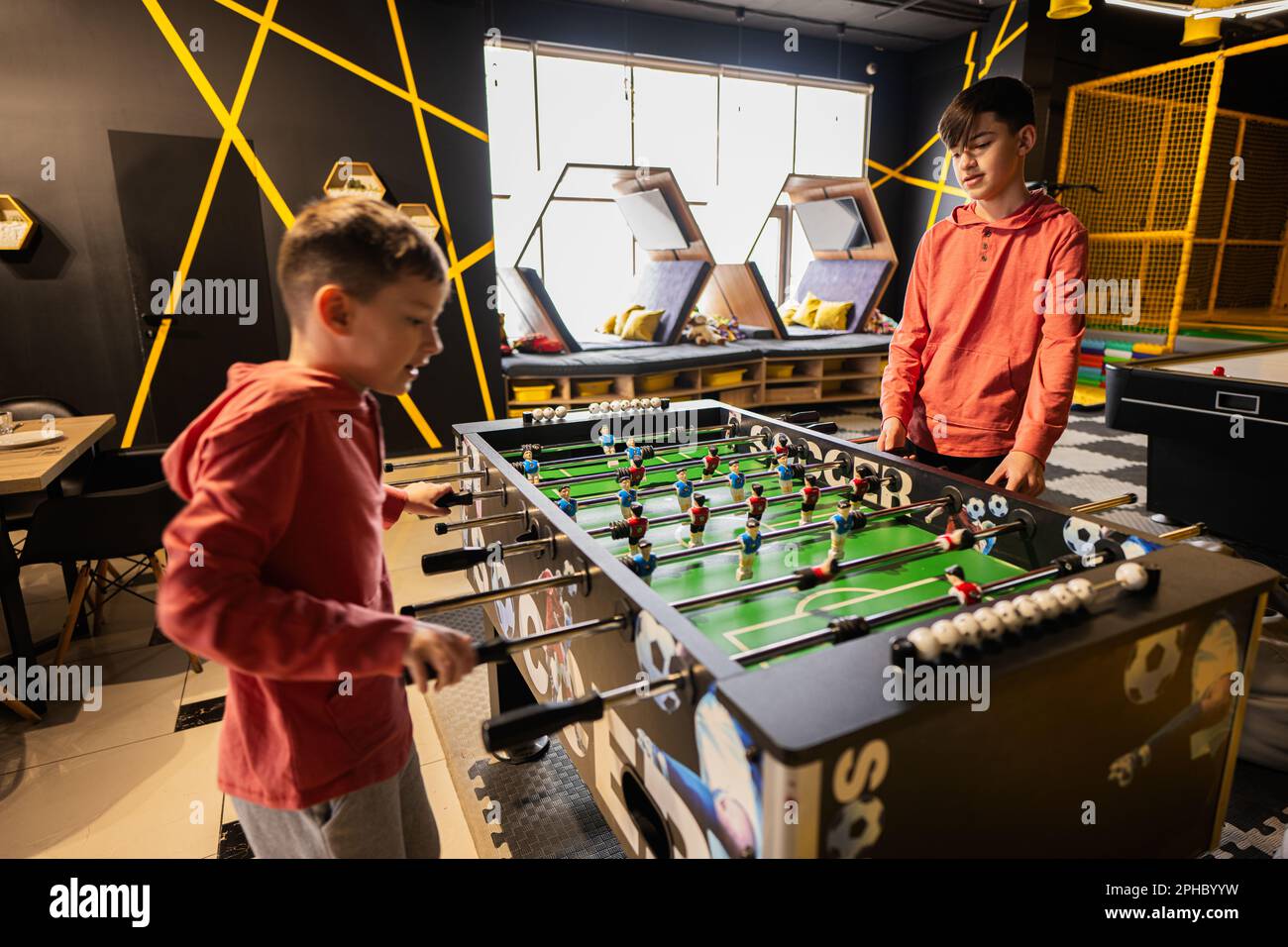 Brothers playing table football in kids play center Stock Photo - Alamy