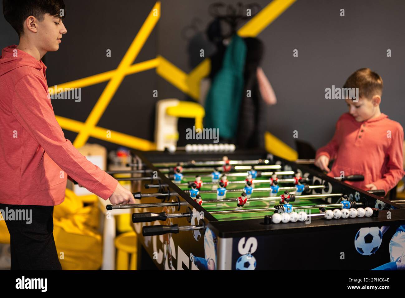 Brothers playing table football in kids play center Stock Photo - Alamy