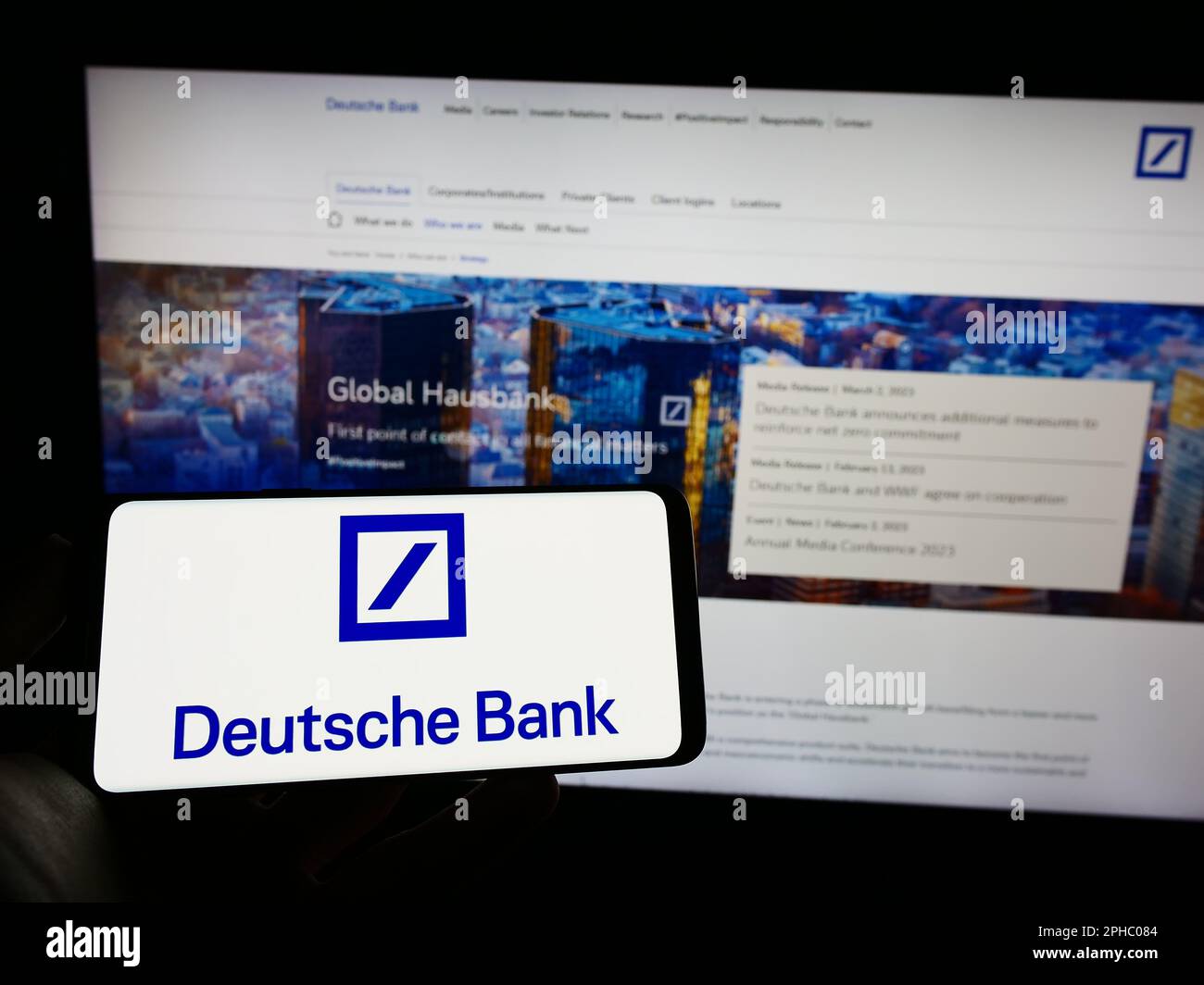 Person holding mobile phone with logo of German financial company ...