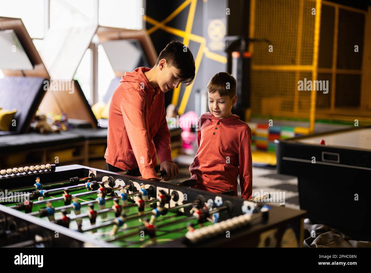 Brothers playing table football in kids play center Stock Photo - Alamy