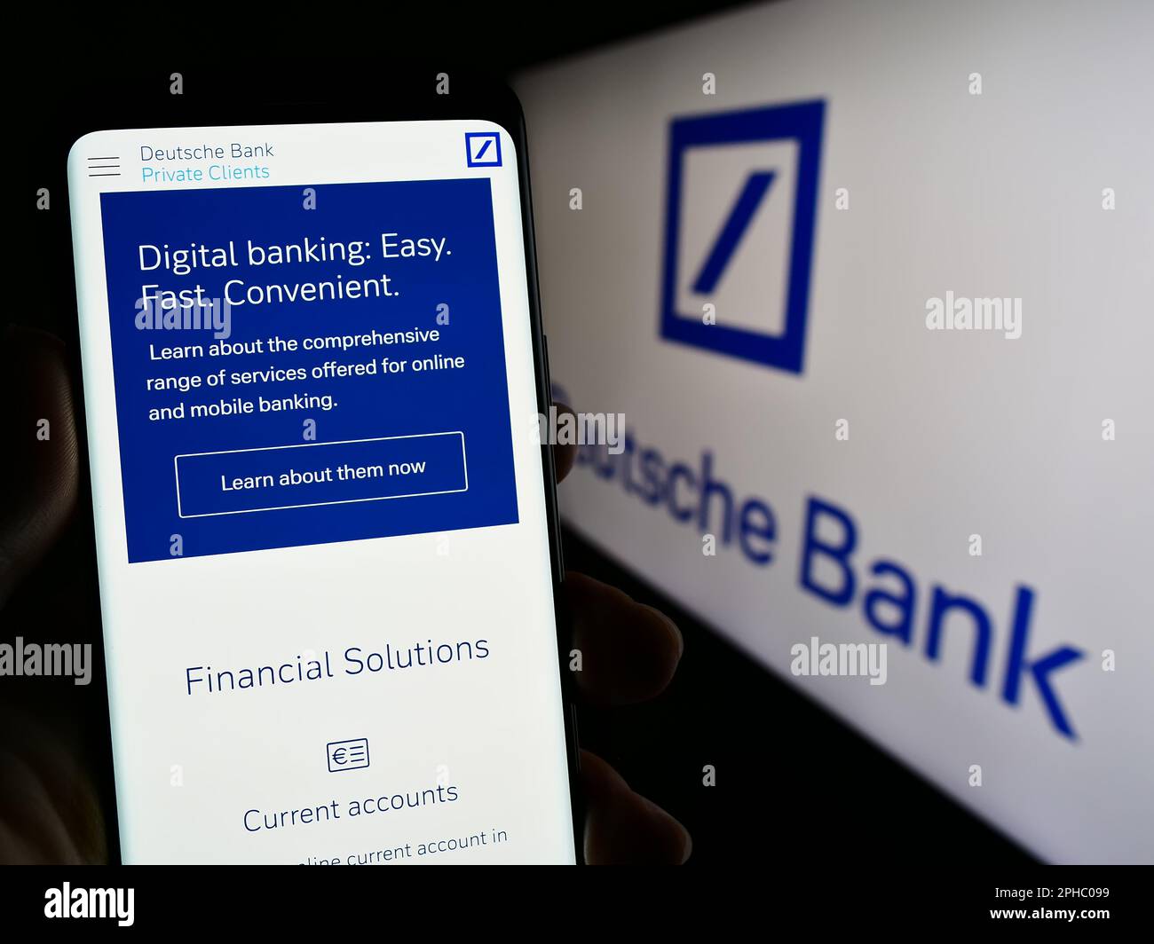 Person holding smartphone with web page of German financial company ...