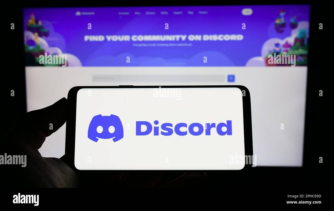 Person holding cellphone with logo of US social network company Discord ...