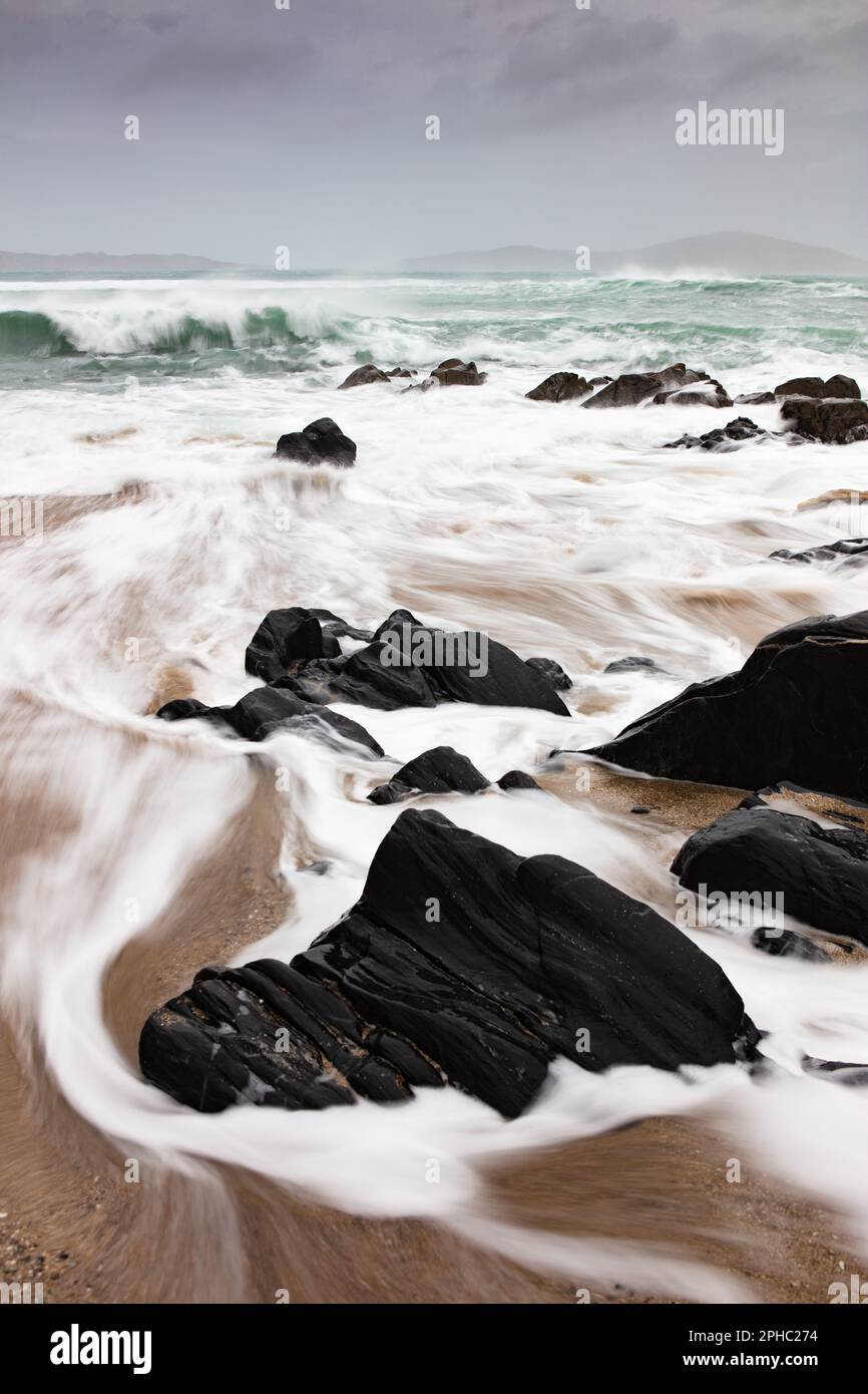 Wave receding down beach Stock Photo - Alamy