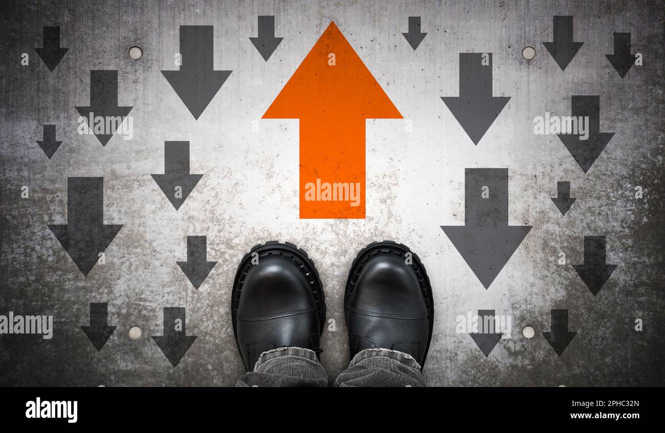 Heavy black leather boots and colorful arrows in opposite directions ...