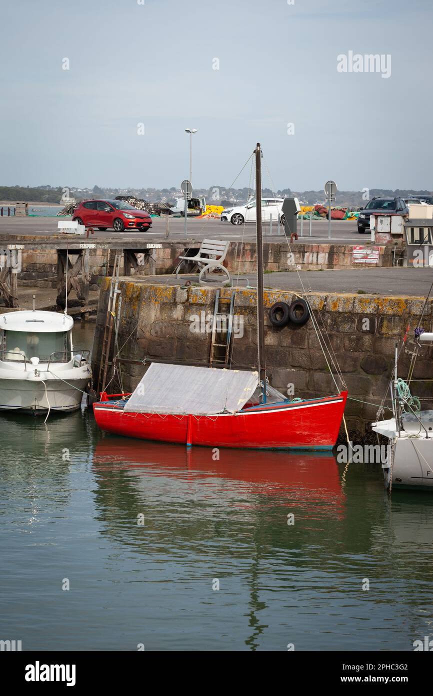 A wooden sailboat is docked, its deck is protected. In front and behind ...