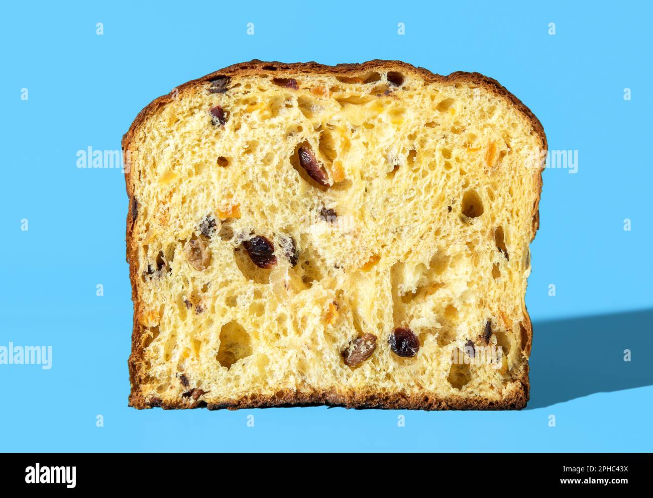 Cross section from a homemade panettone, minimalist on a blue table ...