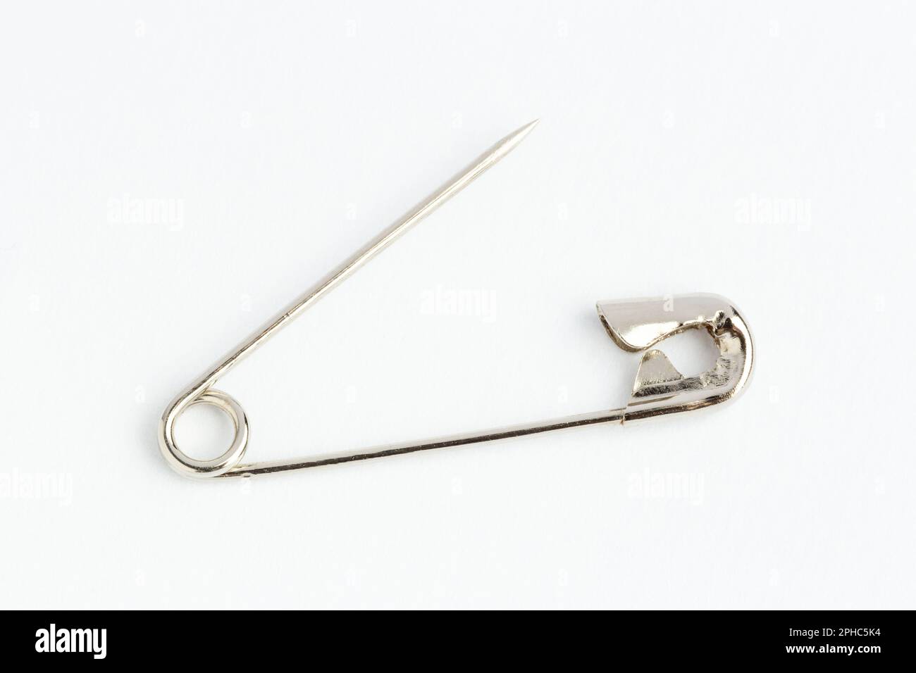 Safety pin on white background Stock Photo - Alamy