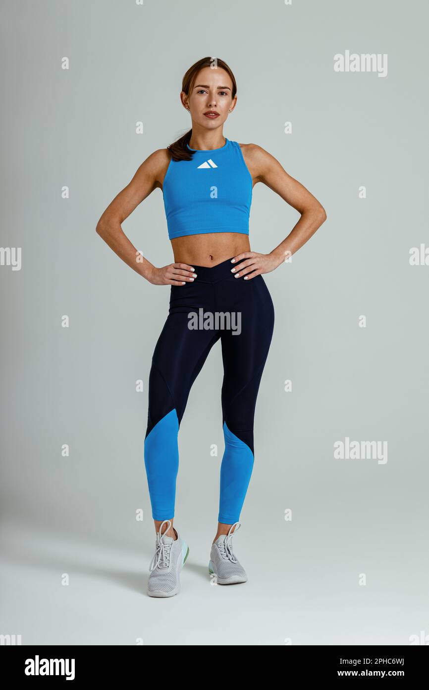 Strong attractive female fitness trainer in sportswear looking at ...