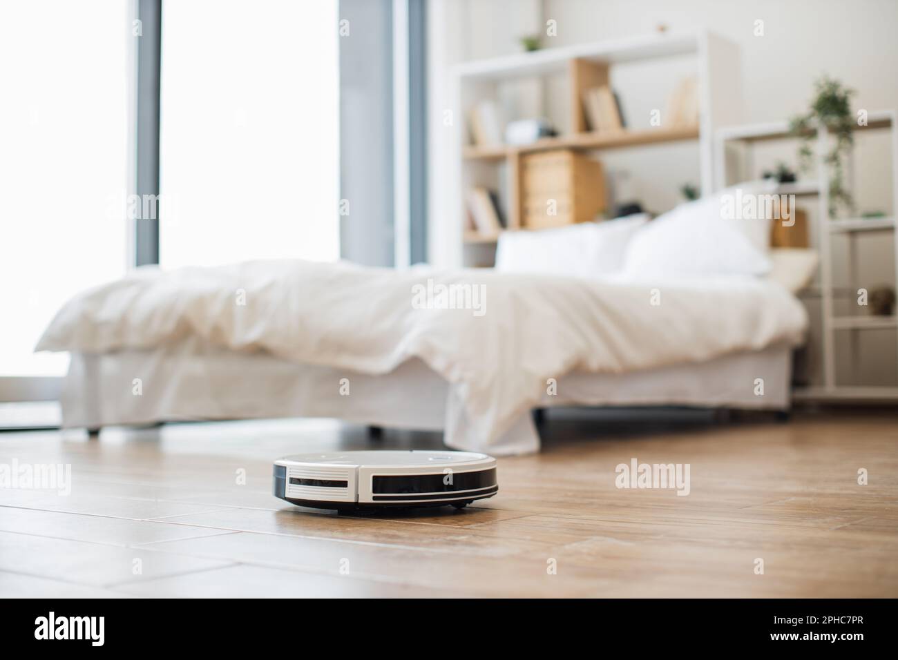 Smart robotic vacuum performing automatic cleaning on laminate floor in ...