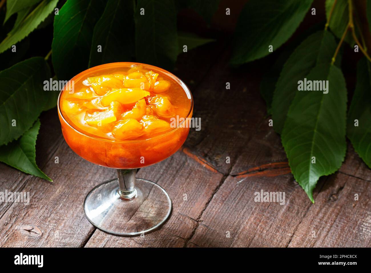 Yellow cherry jam with lemon and vanilla in a glass bowl on a wooden ...