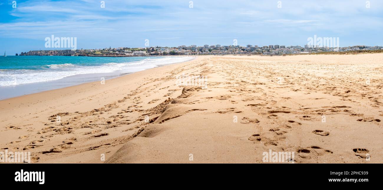 Serene panoramic view at Meia Praia beach during low tide, with the ...