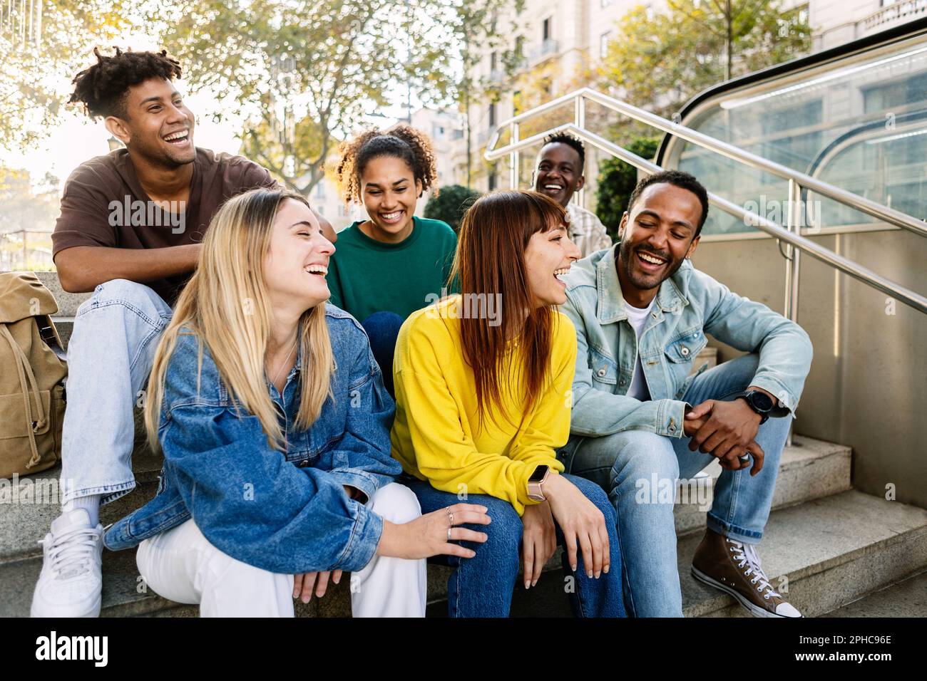 Millennial group of diverse young student friends laughing outdoors ...