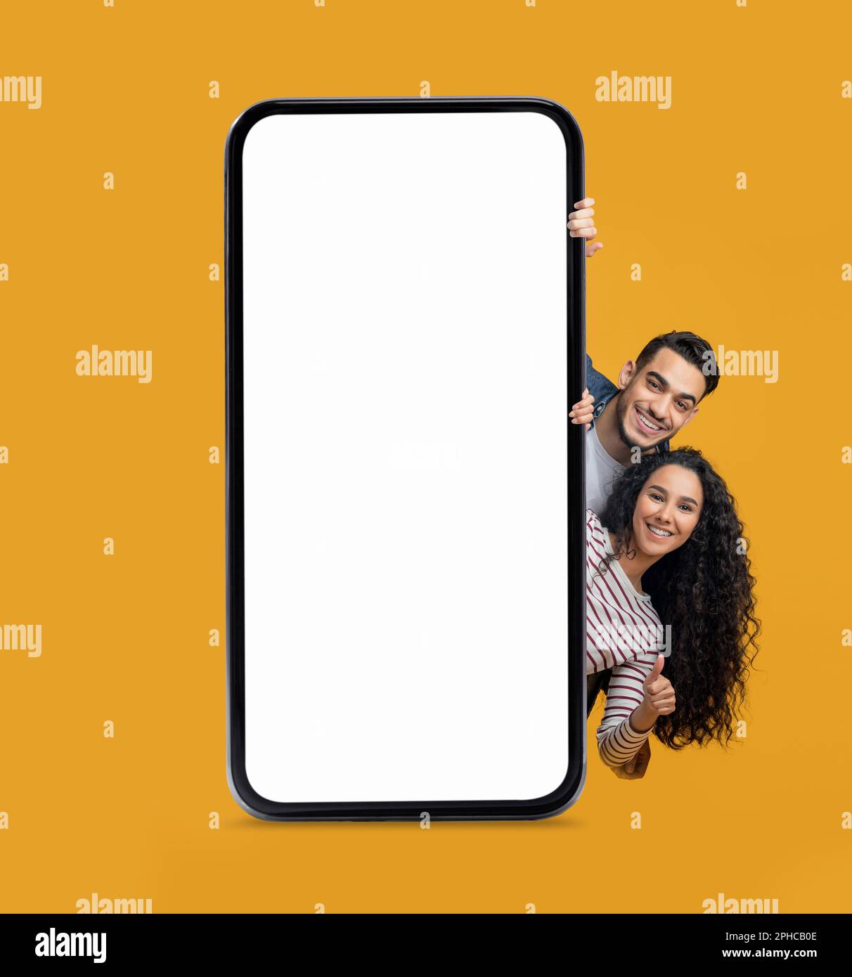 Mobile Mockup. Cheerful Arab Couple Peeking Out Behind Big Blank ...
