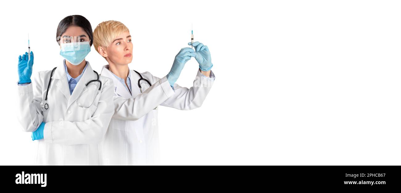 Two Female Doctors With Syringes In Hands Standing Isolated Over White ...
