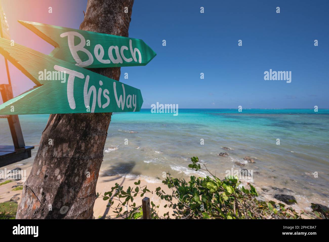 Wooden arrow sigh to beach on blue sea sky background Stock Photo - Alamy